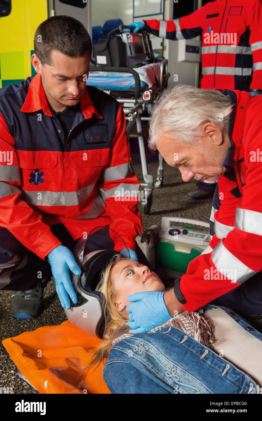 Paramedics removing helmet from motorcycle driver Stock Photo - Alamy