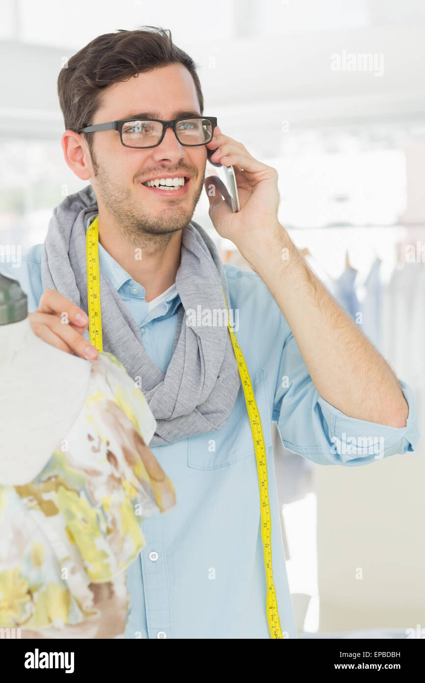 Fashion designer working on dress while using mobile phone Stock Photo ...