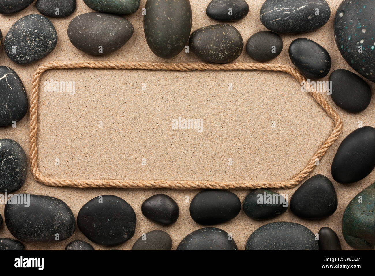 Pointer made of rope with black stones, lying on the sand Stock Photo ...