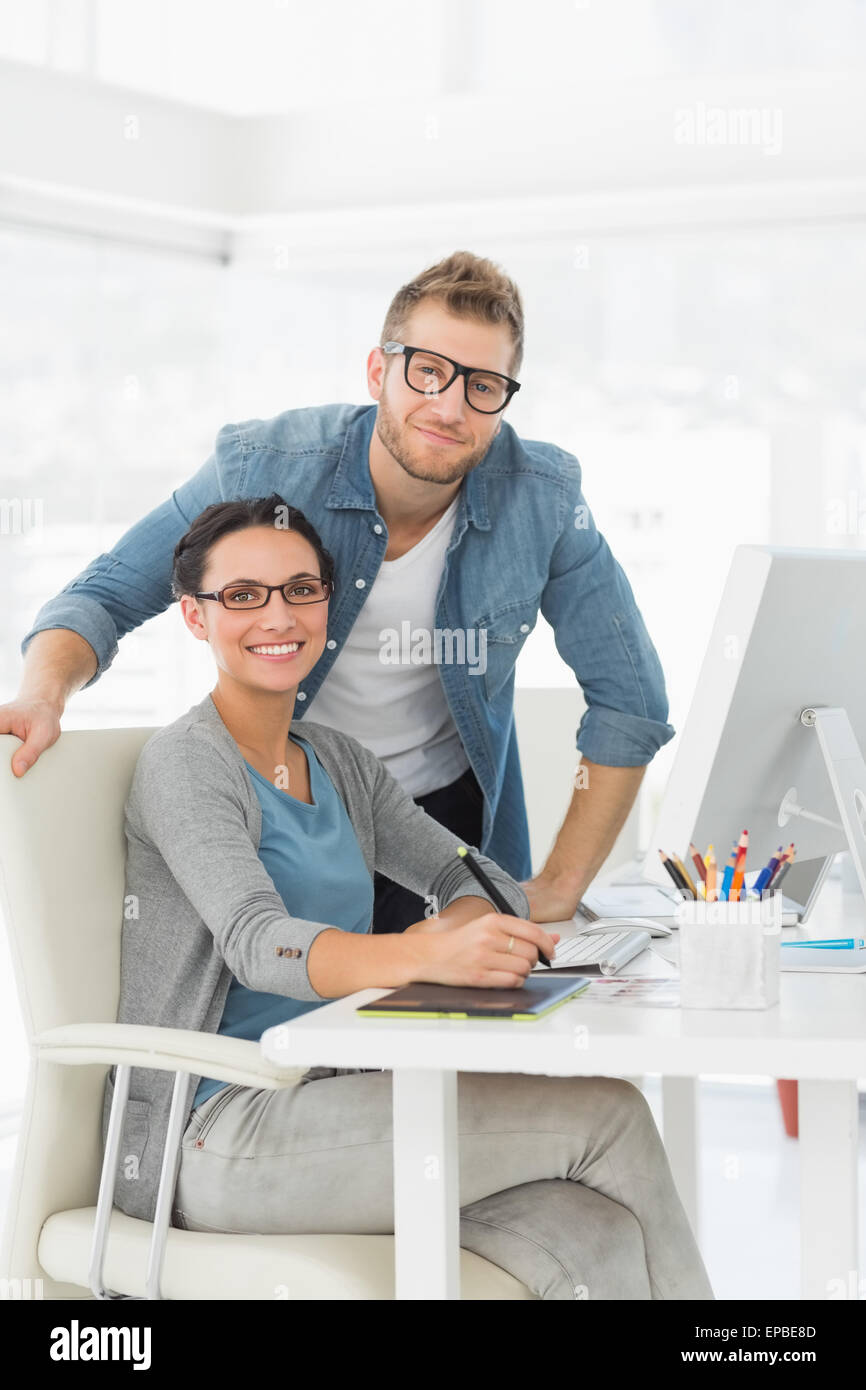 Young design team working at desk smiling at camera Stock Photo - Alamy