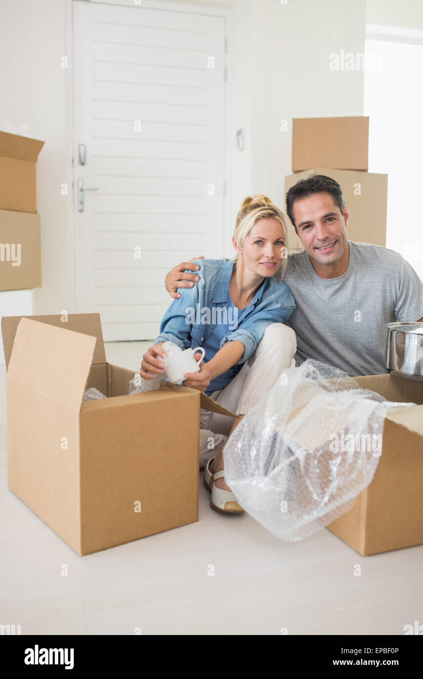 Smiling couple unpacking boxes in a new house Stock Photo - Alamy