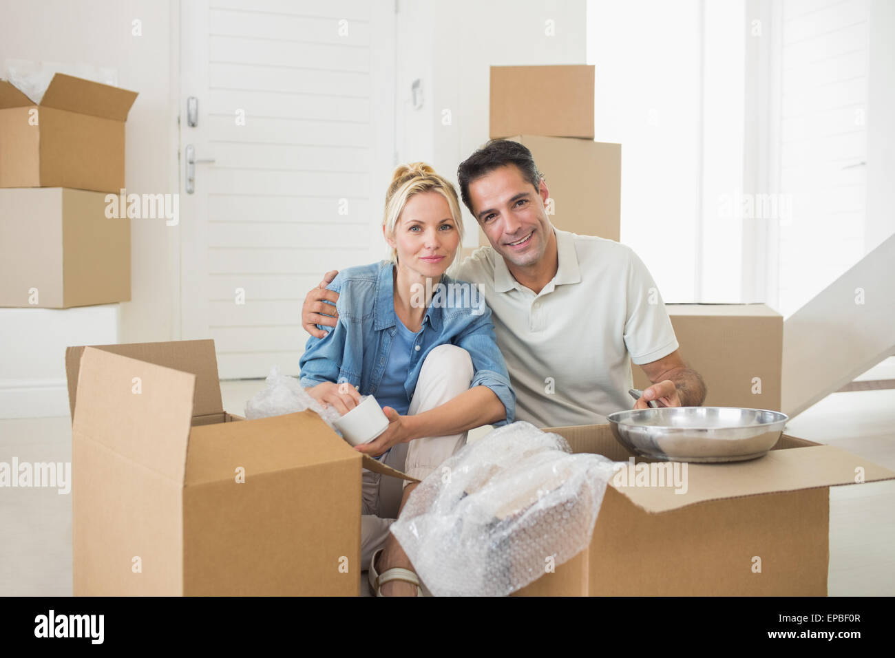 Smiling couple unpacking boxes in a new house Stock Photo - Alamy