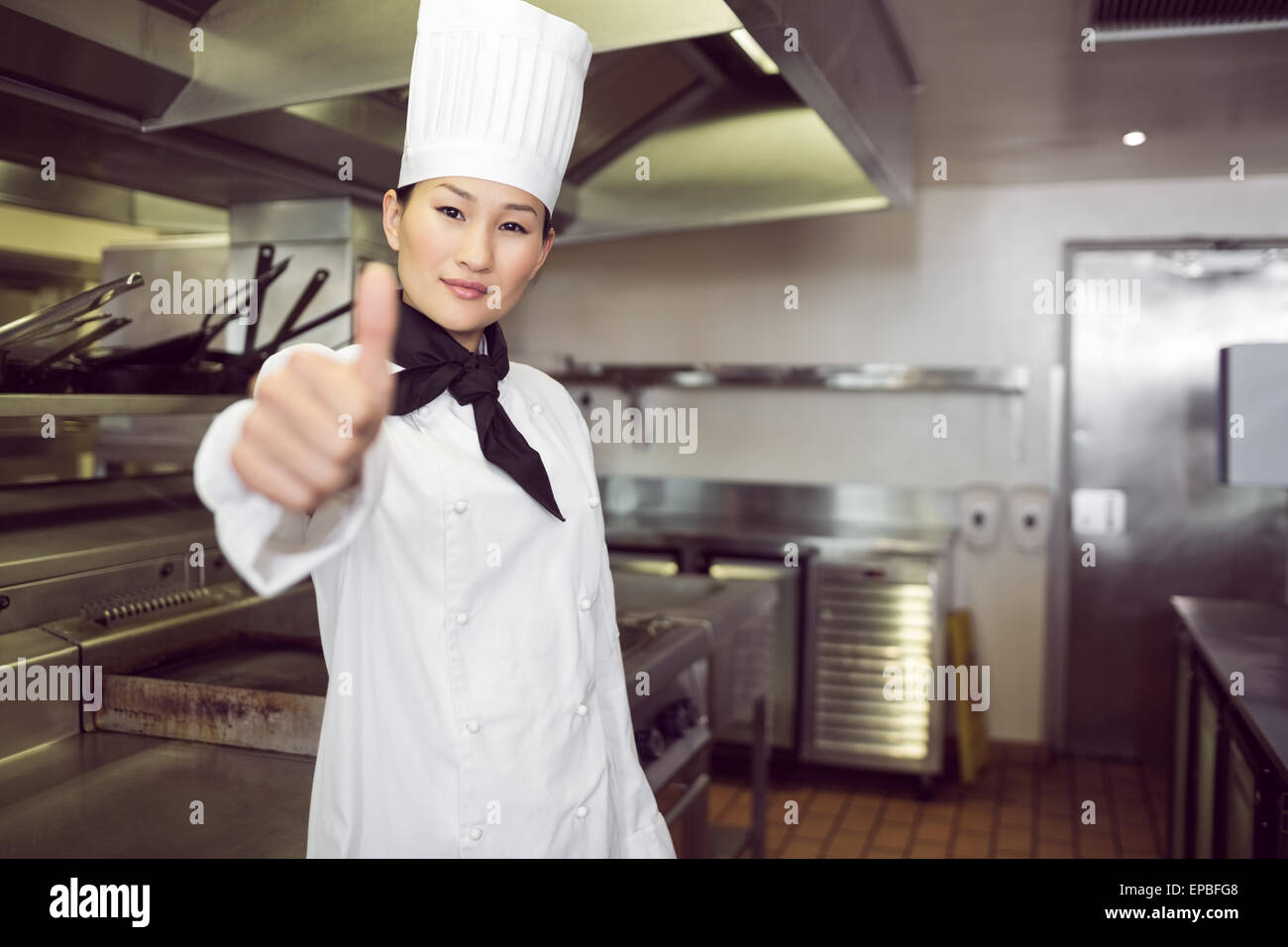 Female cook gesturing thumbs up in kitchen Stock Photo - Alamy