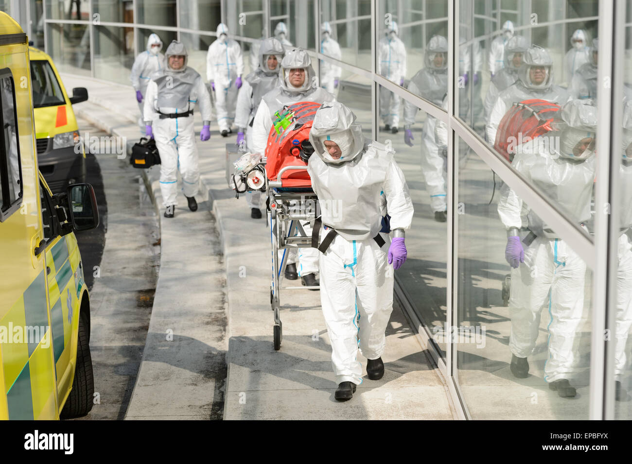 Biohazard medical team walking to building Stock Photo - Alamy