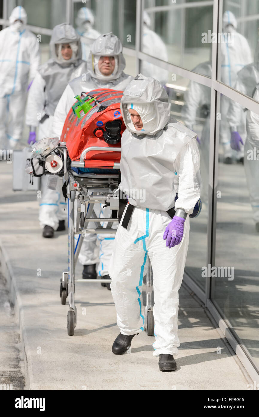 Biohazard medical team with stretcher outside building Stock Photo - Alamy