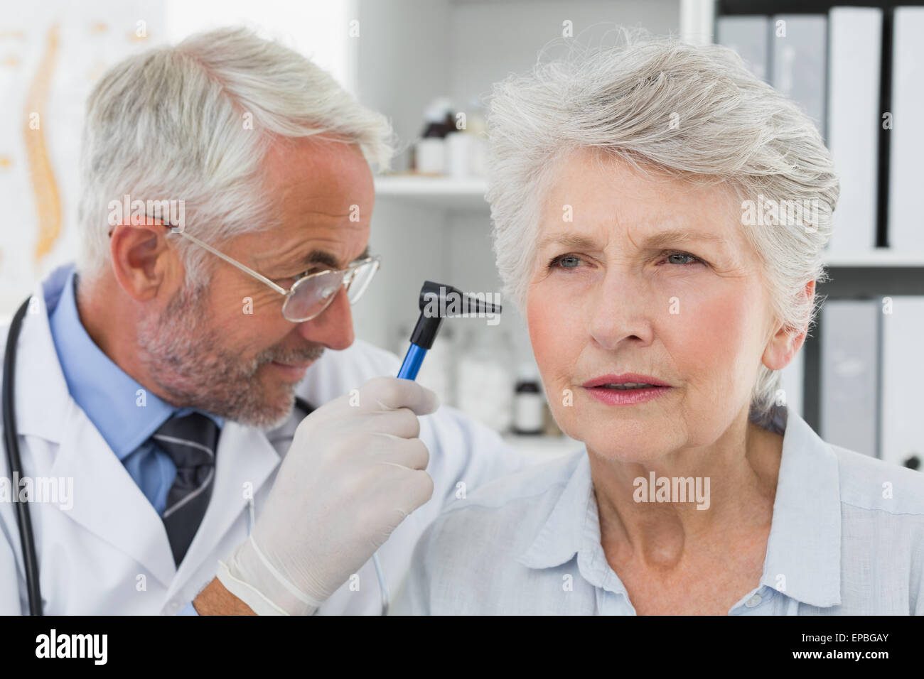 Doctor examining senior patient's ear Stock Photo - Alamy