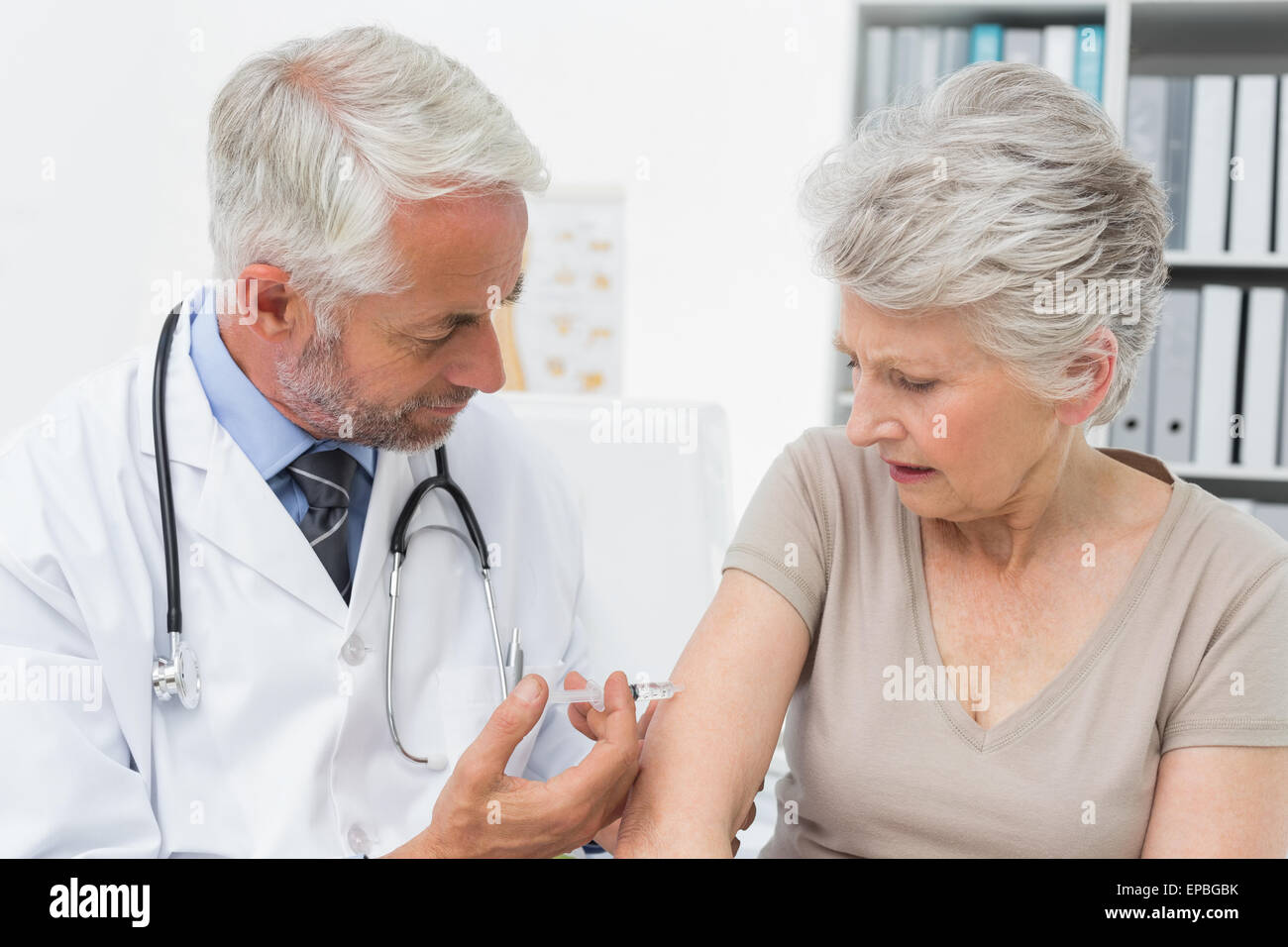 Male doctor injecting senior female patient Stock Photo - Alamy