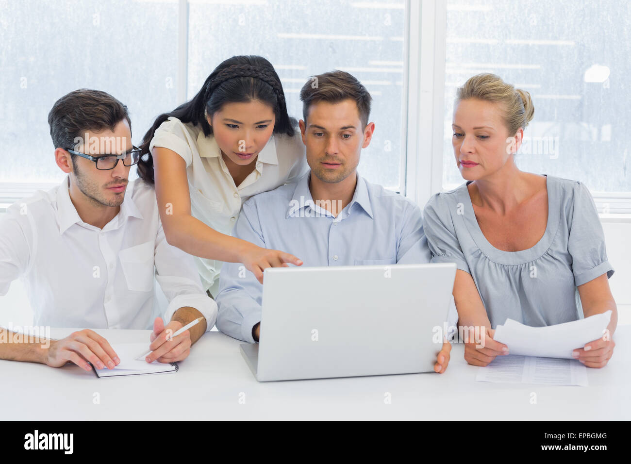 Casual business team working together at desk using laptop Stock Photo ...