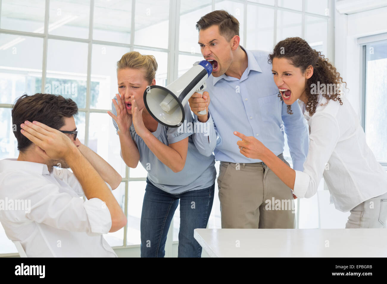 Casual business team shouting at a colleague Stock Photo - Alamy