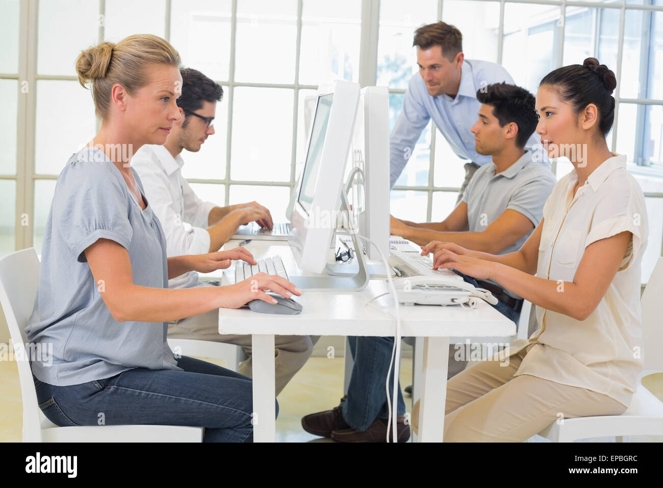 Casual business team working on computers Stock Photo - Alamy