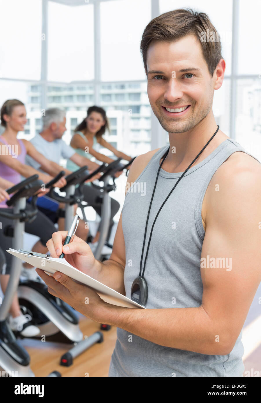 Trainer with people working out at spinning class Stock Photo - Alamy