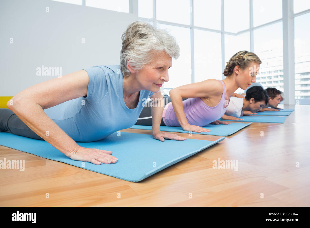 Group doing cobra pose in row at yoga class Stock Photo - Alamy