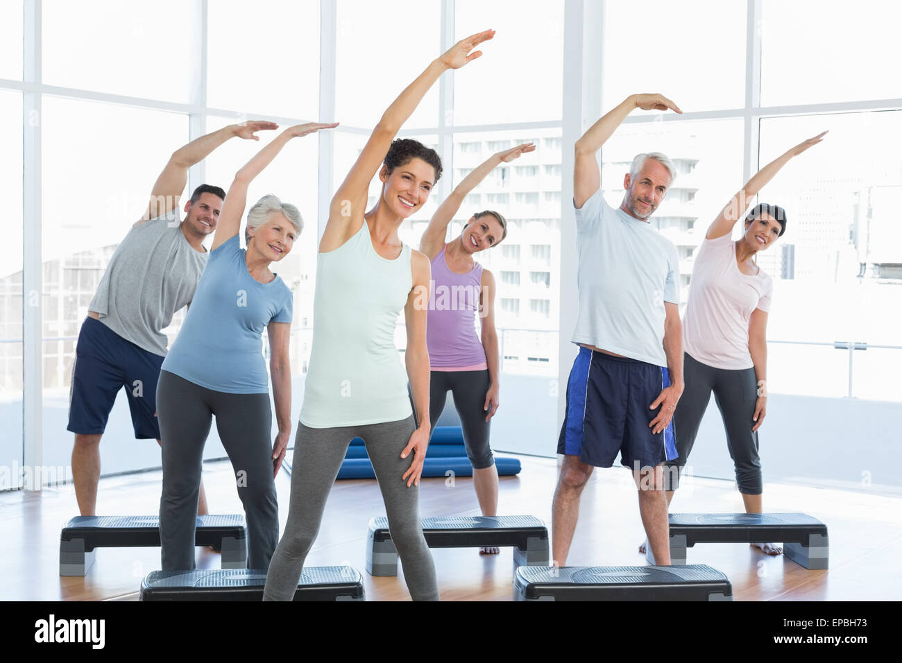 Class stretching hands in yoga class Stock Photo - Alamy