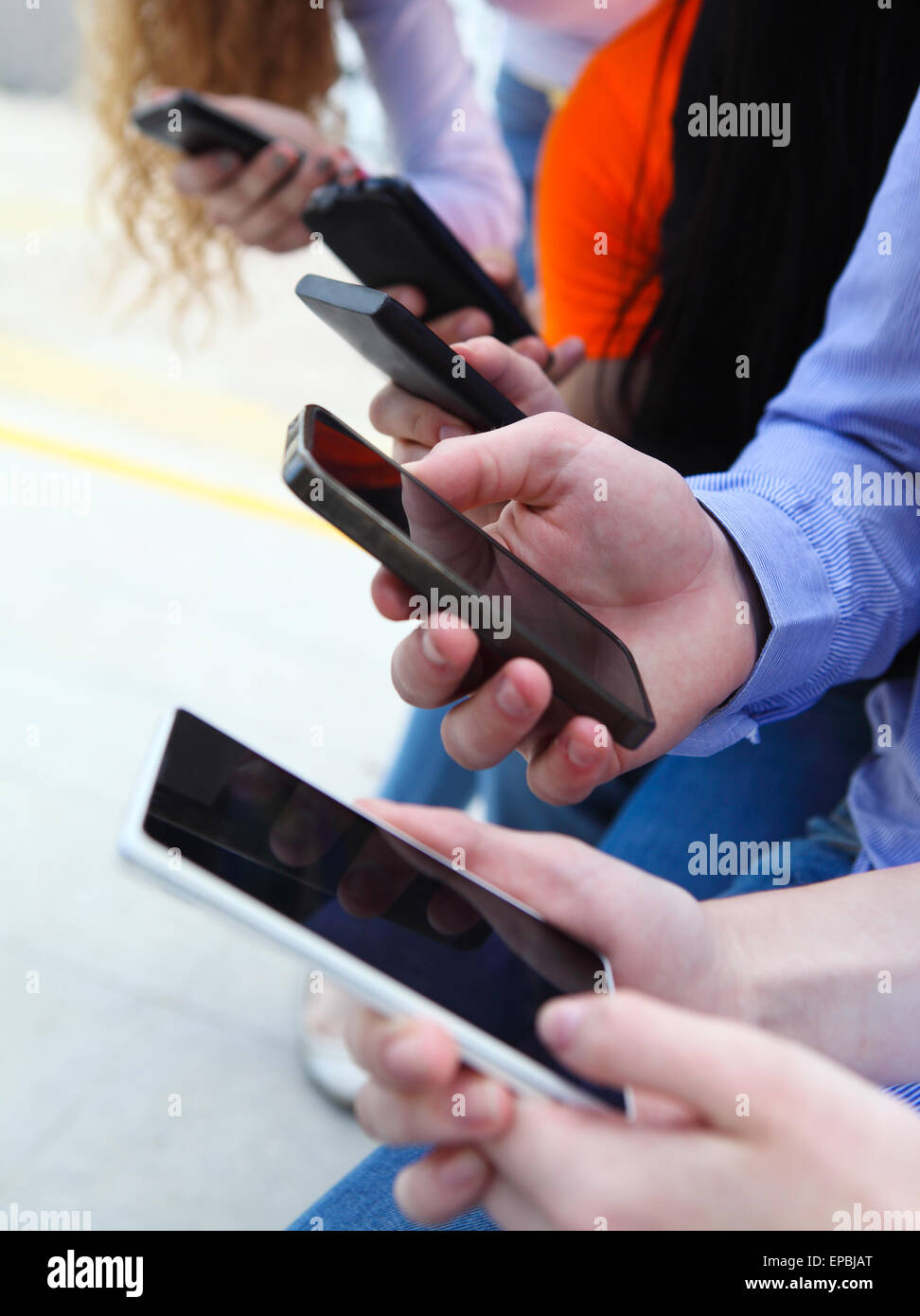 Group of a students chatting with their smartphones Stock Photo - Alamy