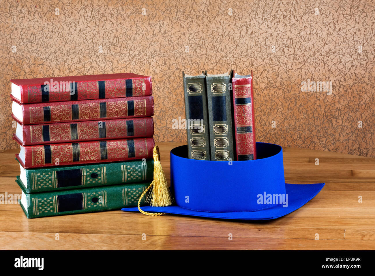 Graduation mortarboard on top of stack of books on abstract background ...