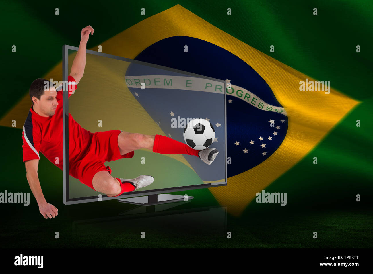 Fit football player kicking ball through tv Stock Photo - Alamy