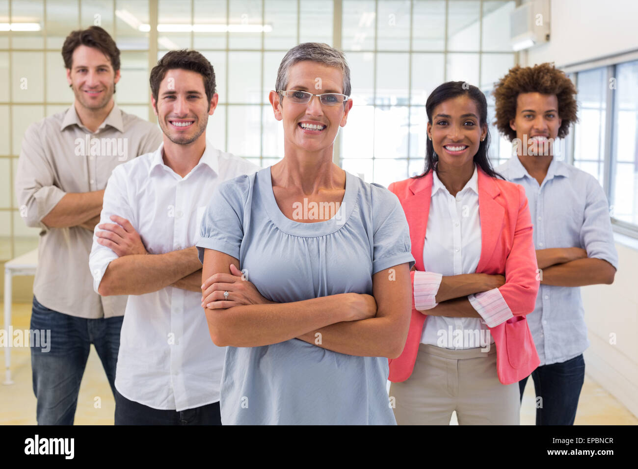Leader and staff standing smiling with arms crossed Stock Photo - Alamy