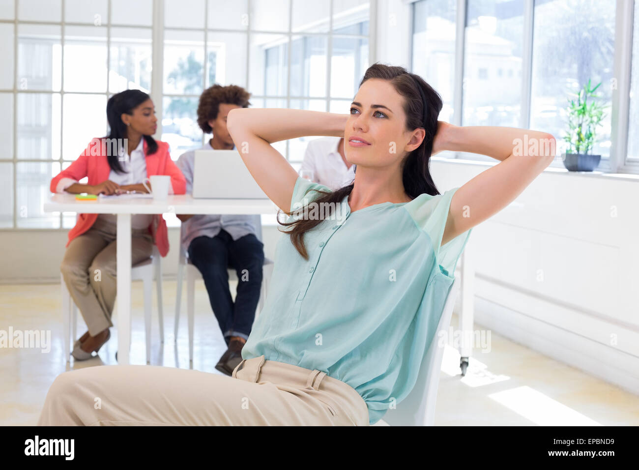 Attractive office worker relaxing with colleagues working behind Stock ...