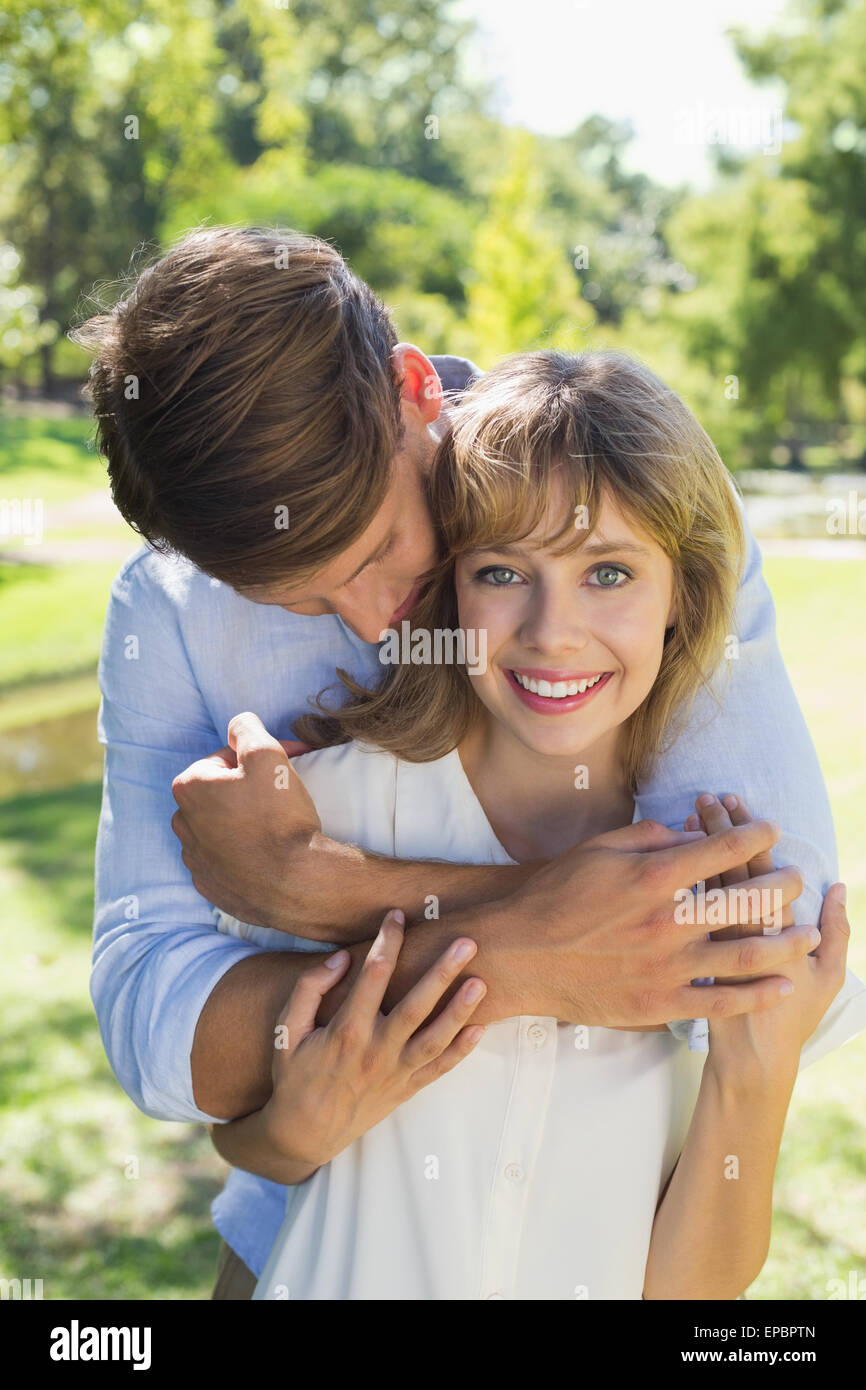 Cute couple hugging in the park with girl smiling at camera Stock Photo ...