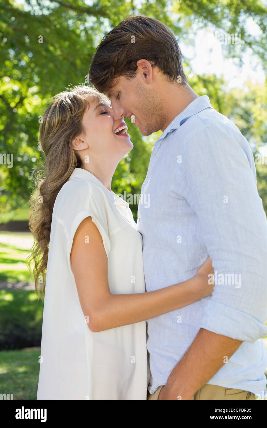 Cute couple hugging and laughing in the park Stock Photo - Alamy
