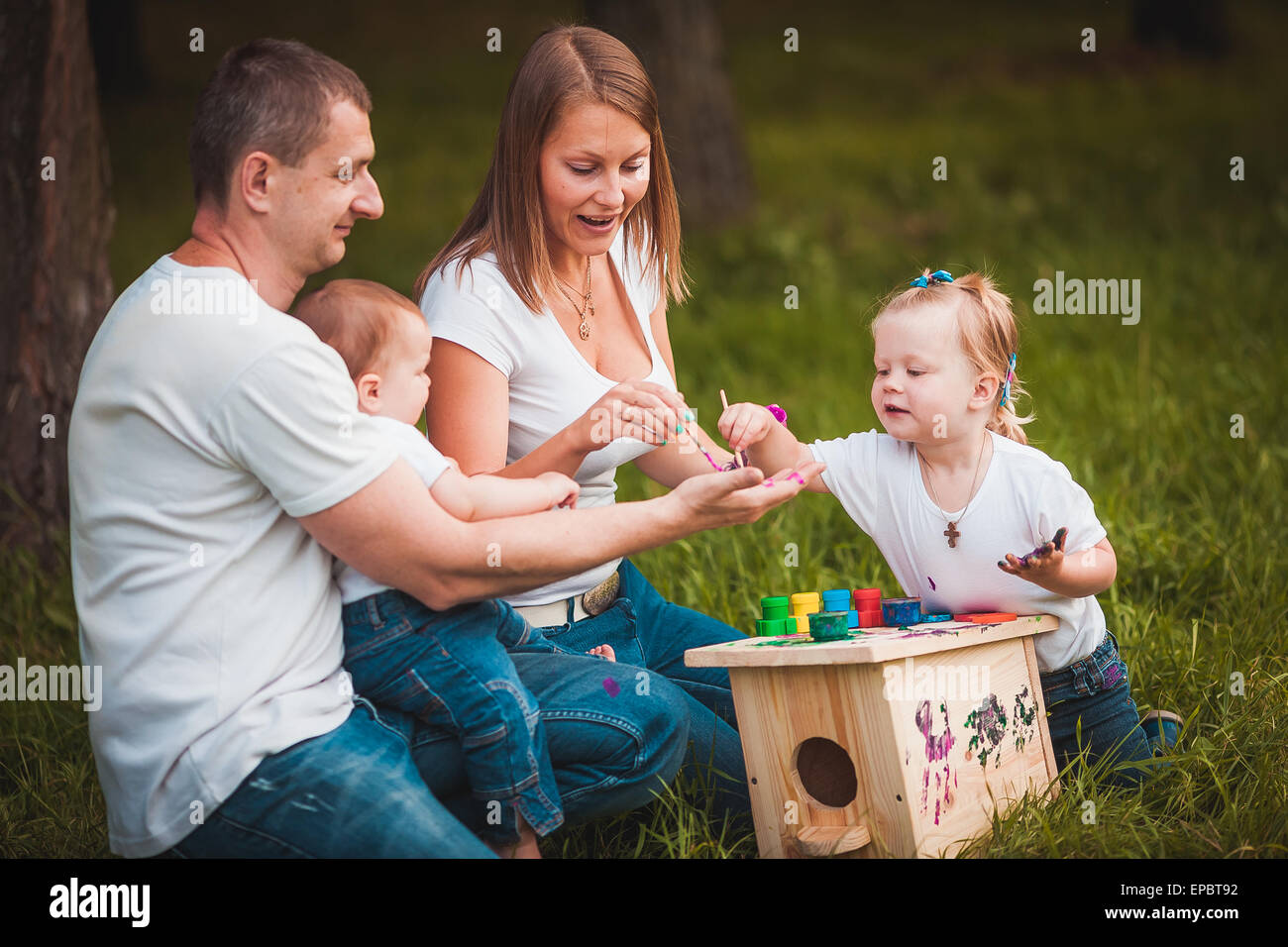 Happy family with nesting box and paints Stock Photo - Alamy