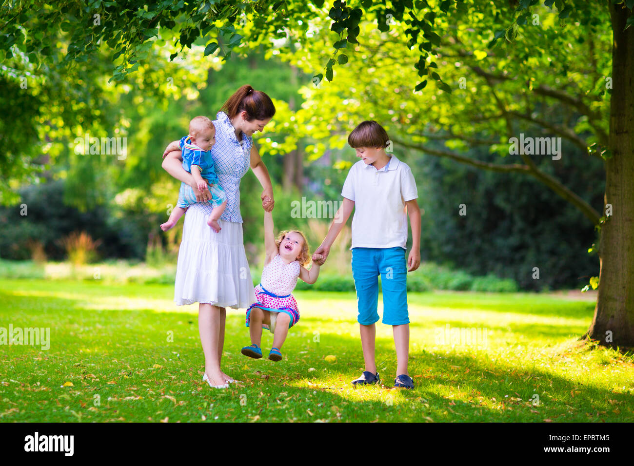 Happy family with three kids in a park. Young mother with children ...