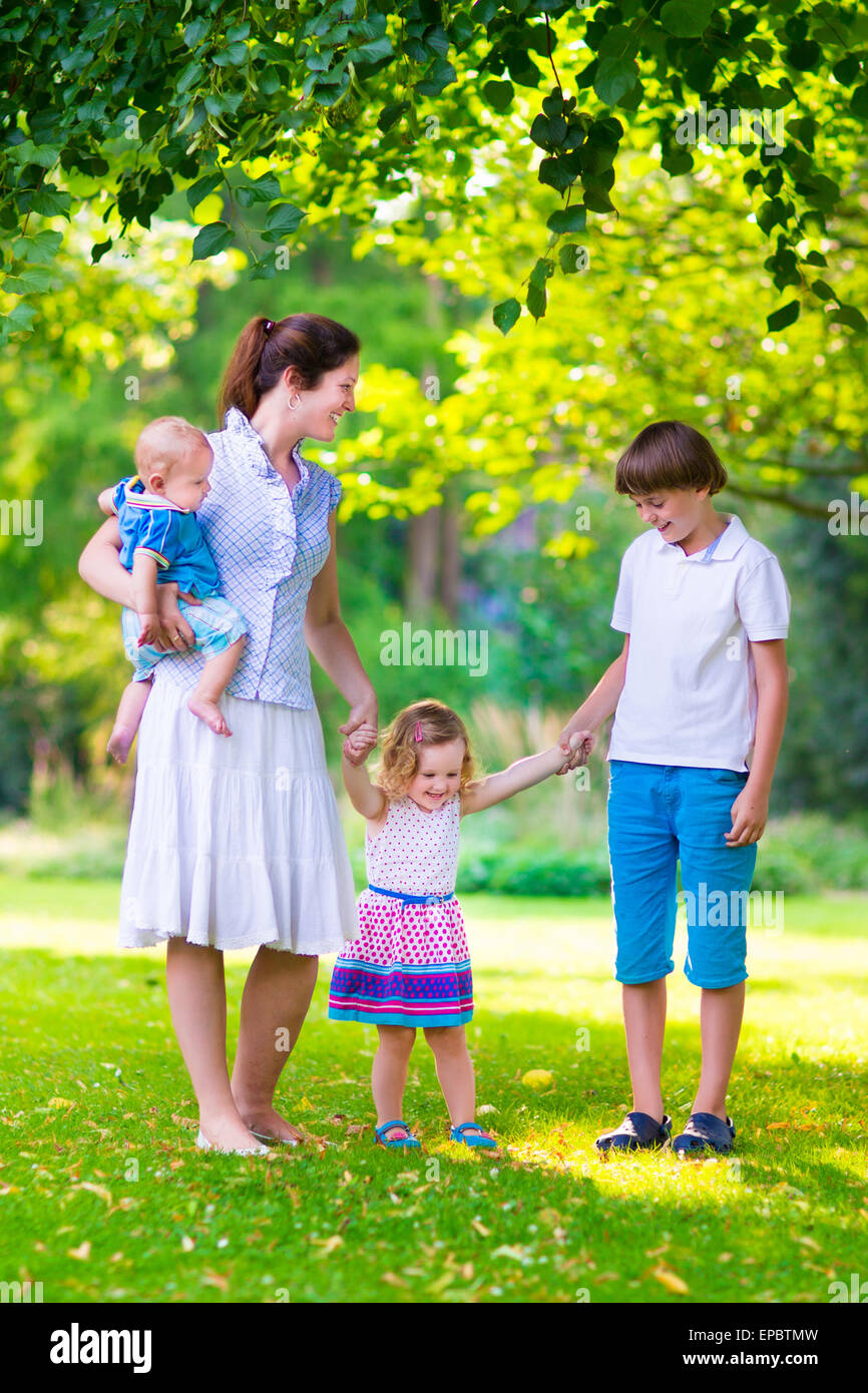 Happy family with three kids in a park. Young mother with children ...