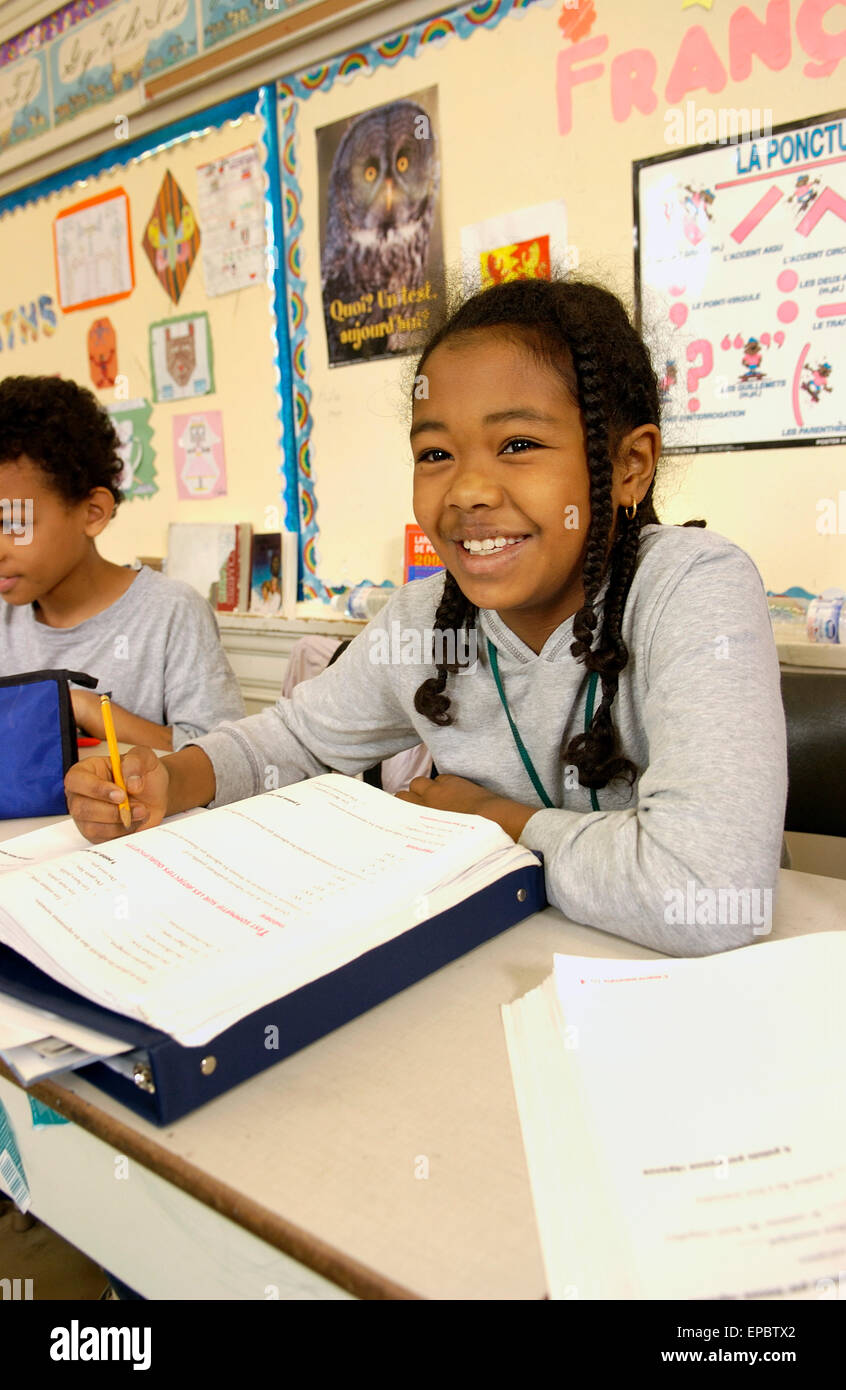 Grade 5 female student working at her desk in the classroom Stock Photo ...