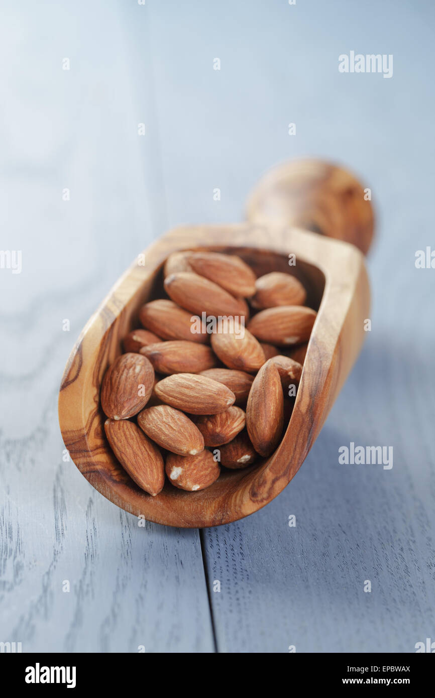 roasted almonds in measuring scoop on blue wooden table Stock Photo - Alamy