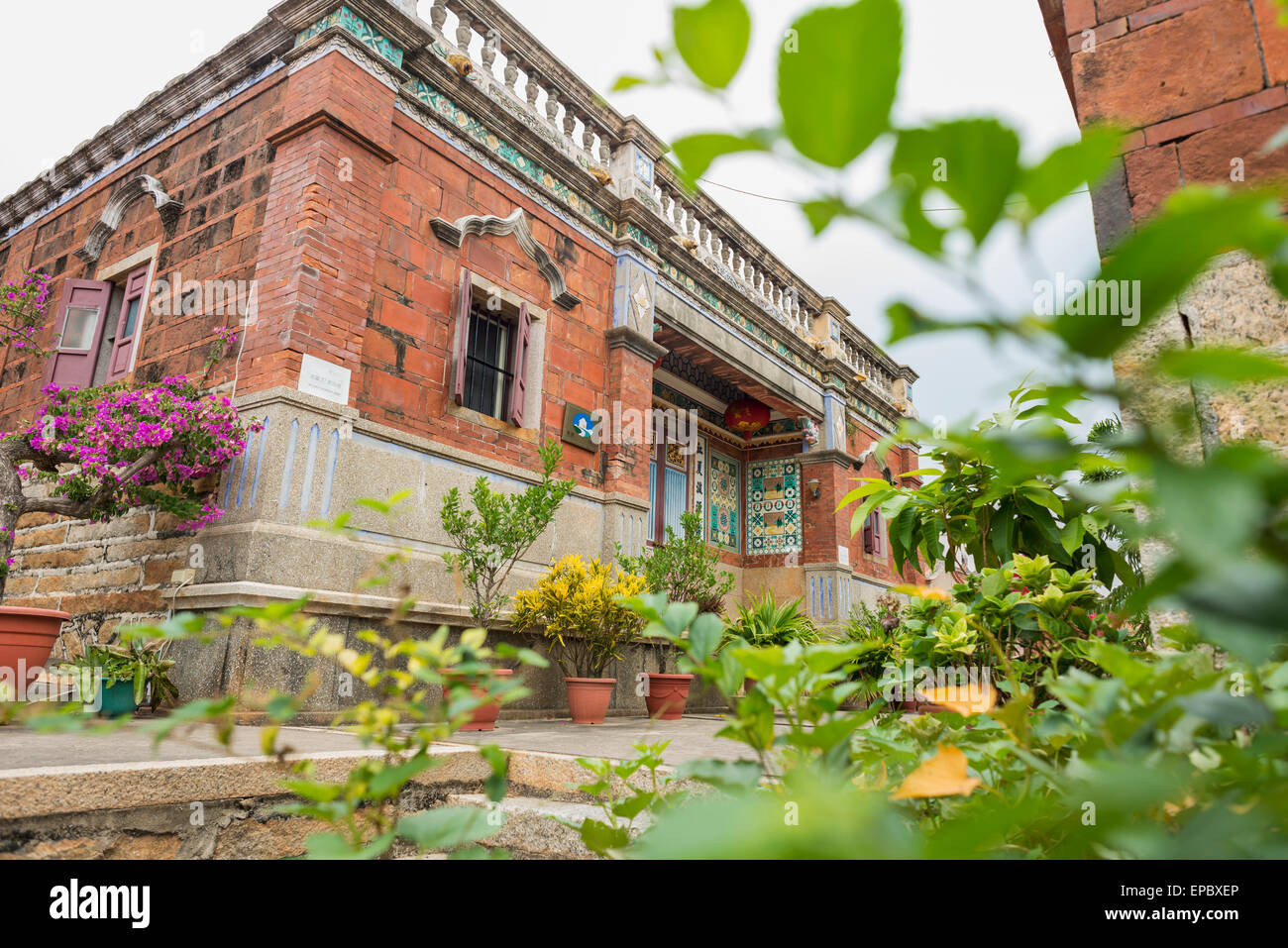 Building with decorative plants and flowers around the exterior ...
