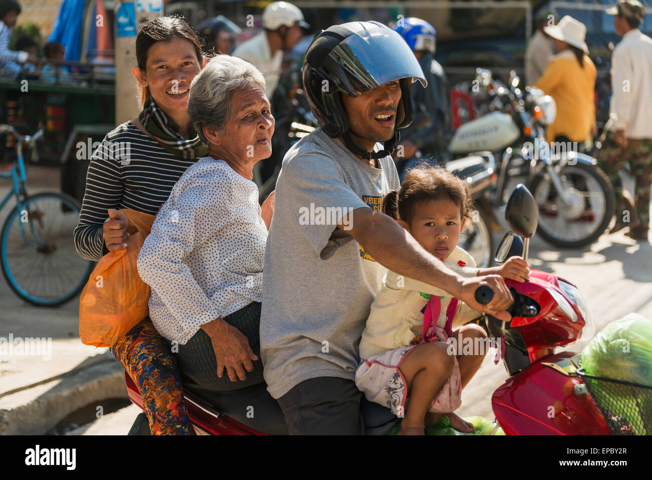 A family of four ride on a motorcycle at the Old Market; Battambang ...