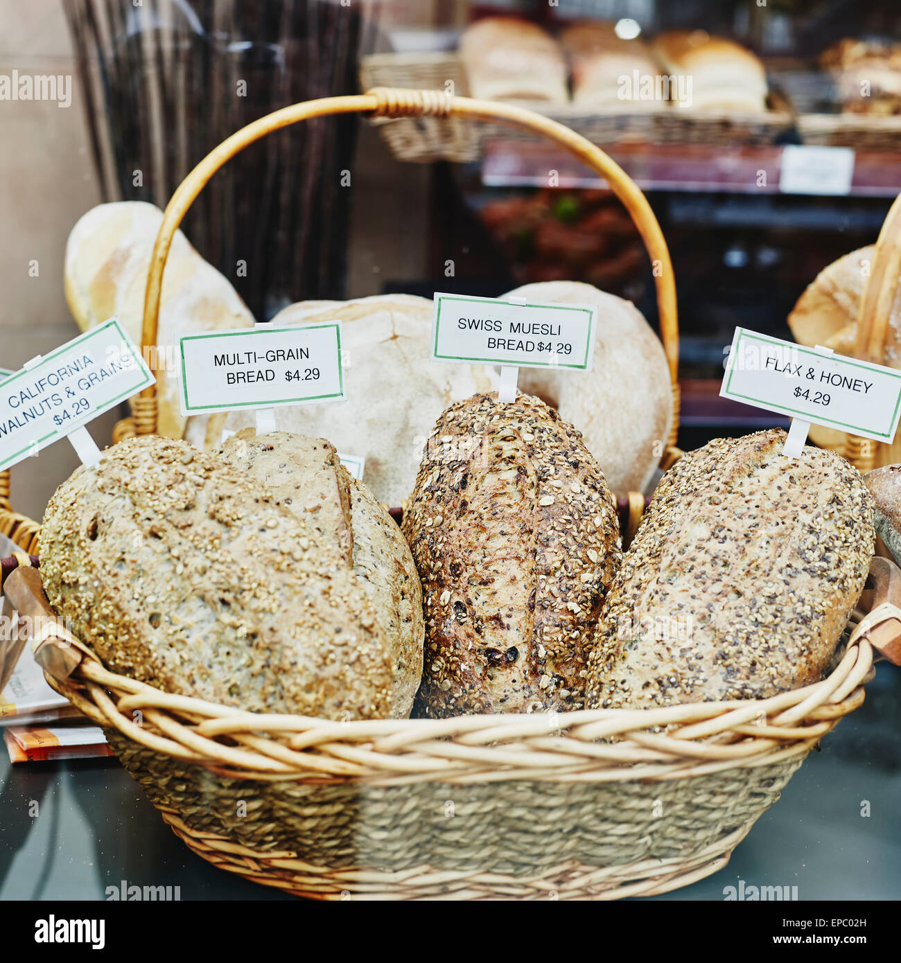 Basket of a variety of healthy breads for sale in bakery display case ...