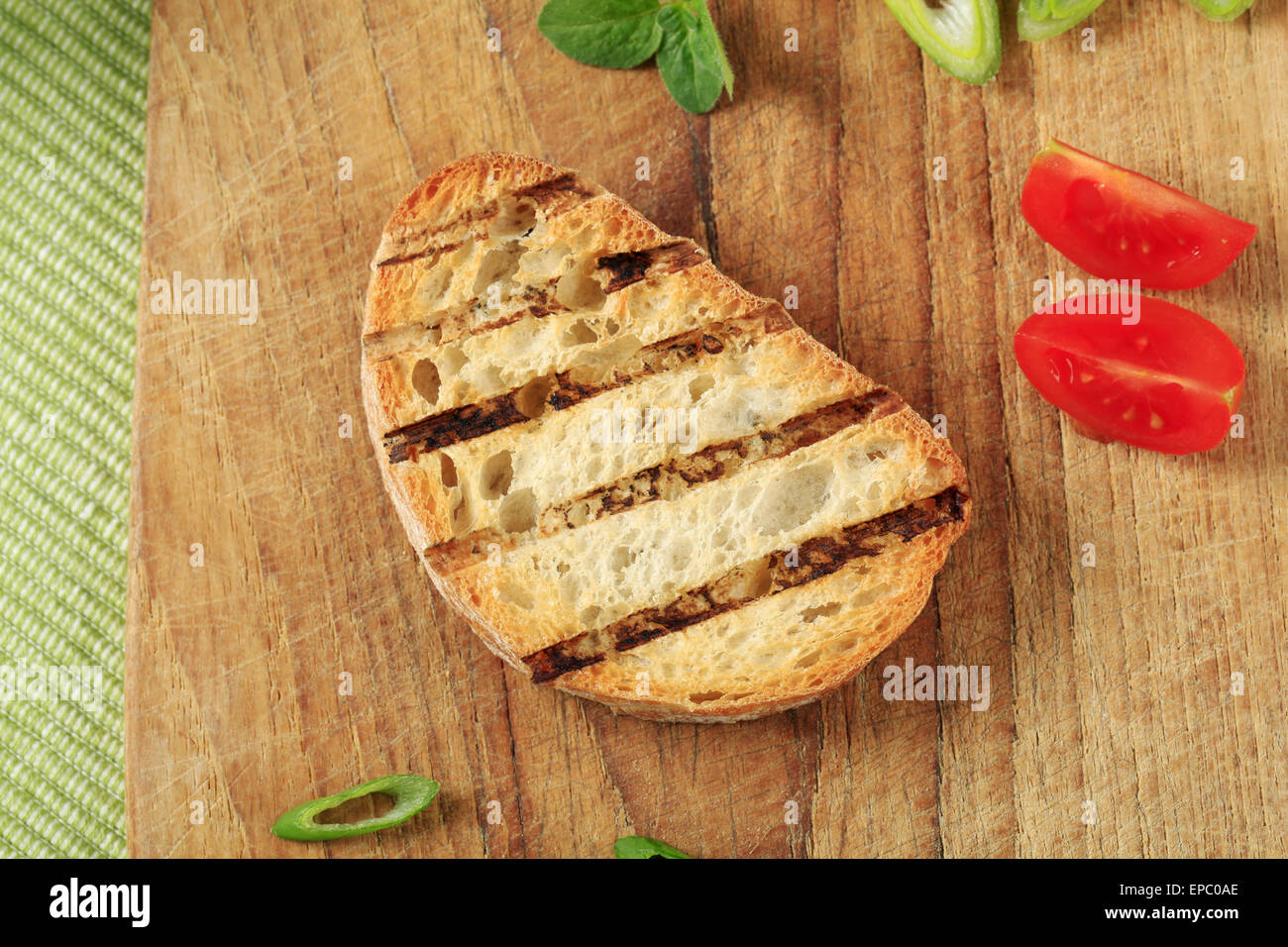 Slice of grill toasted bread on a cutting board Stock Photo - Alamy