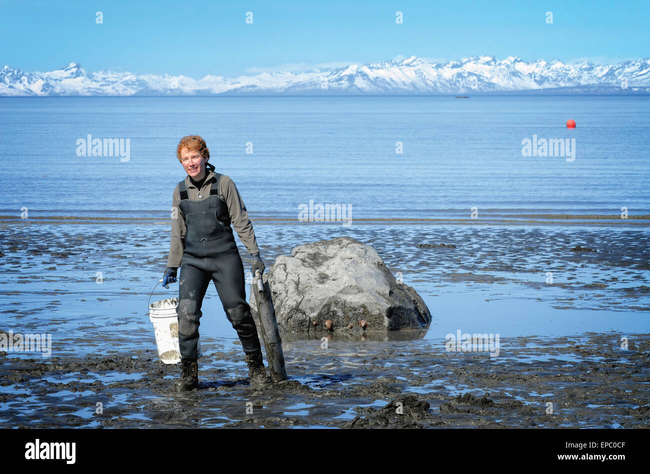 Woman carrying a bucket and clamming gun while clamming for Razor Clams ...