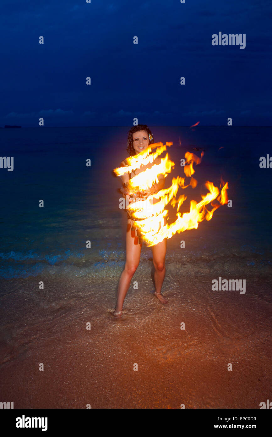 woman in bikini in ocean with fire fans Stock Photo - Alamy
