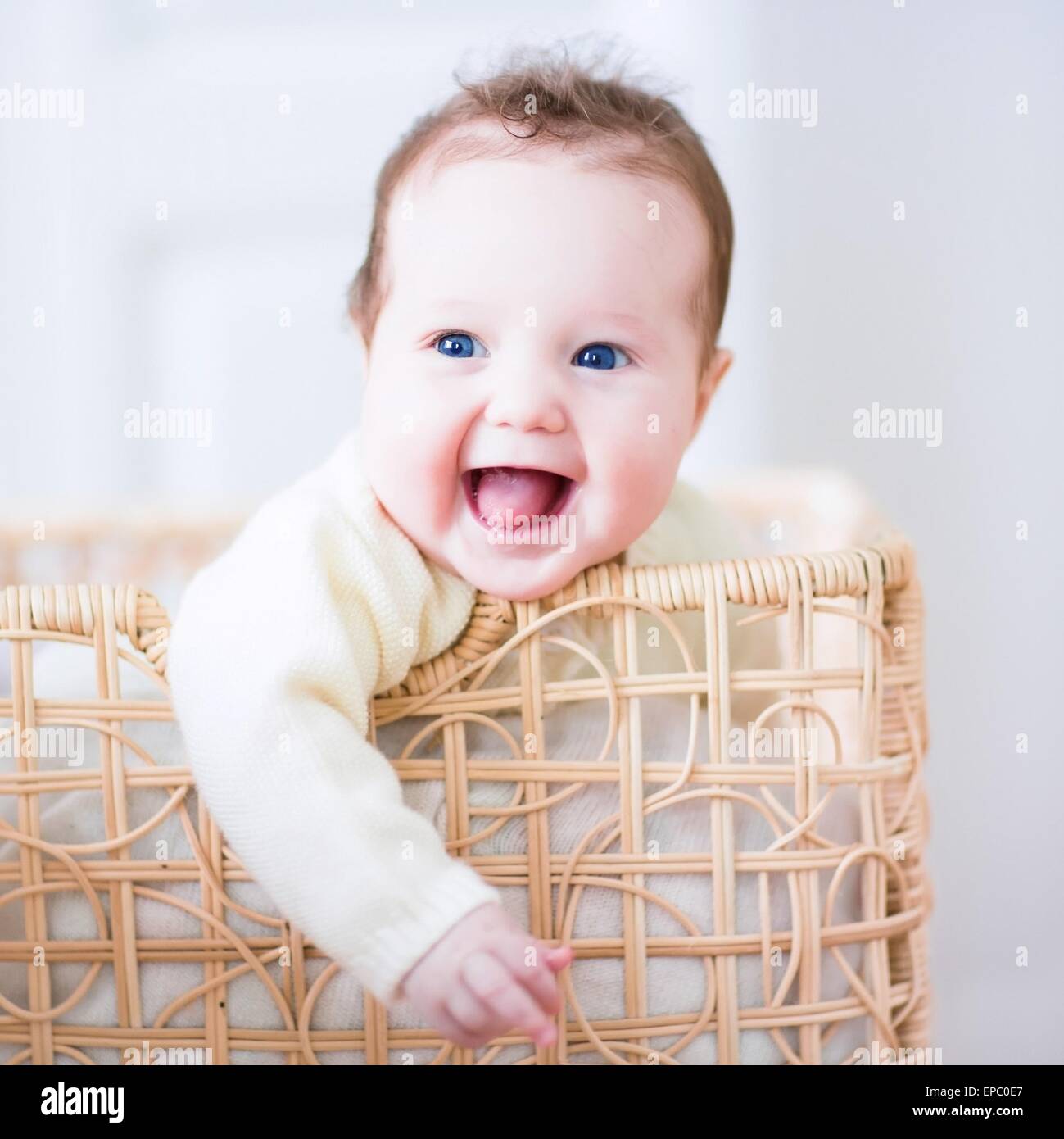 Adorable laughing baby sitting in a laundry basket Stock Photo - Alamy