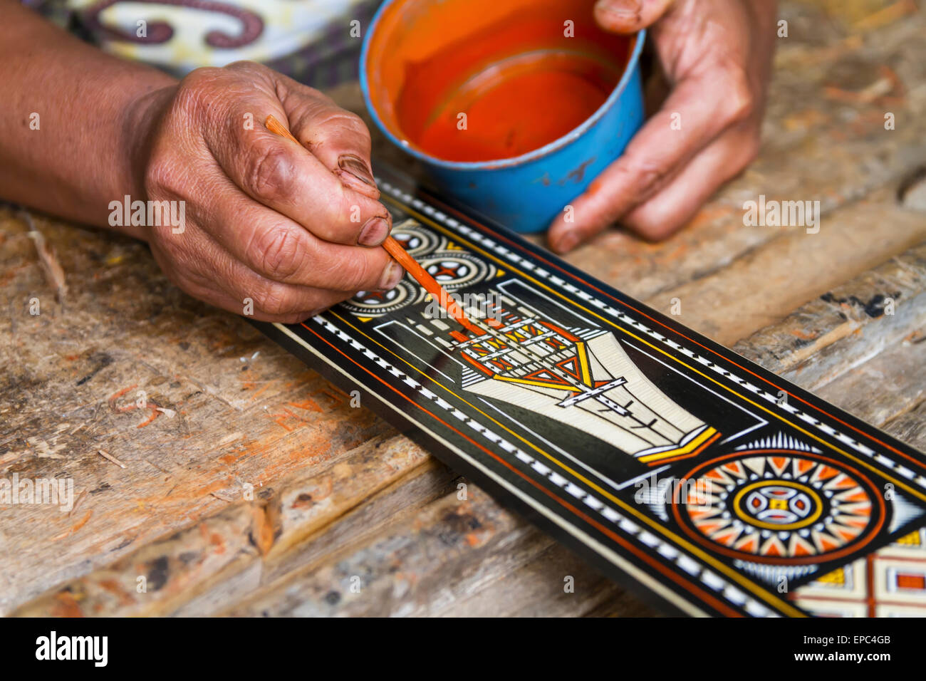 Man painting a traditional Toraja design on piece of wood, Kete Kesu ...