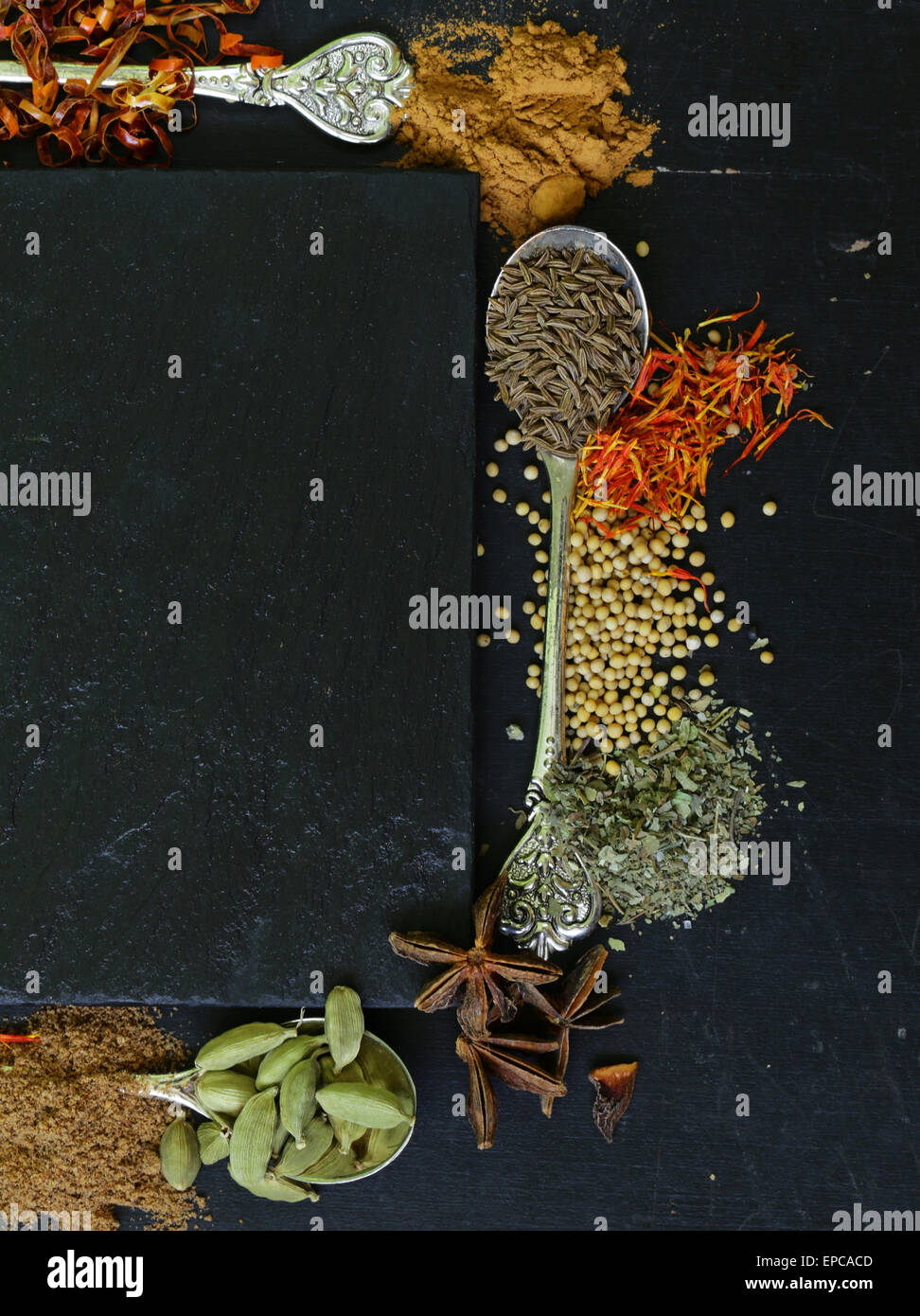 Different spices on a black background (paprika, turmeric, pepper ...