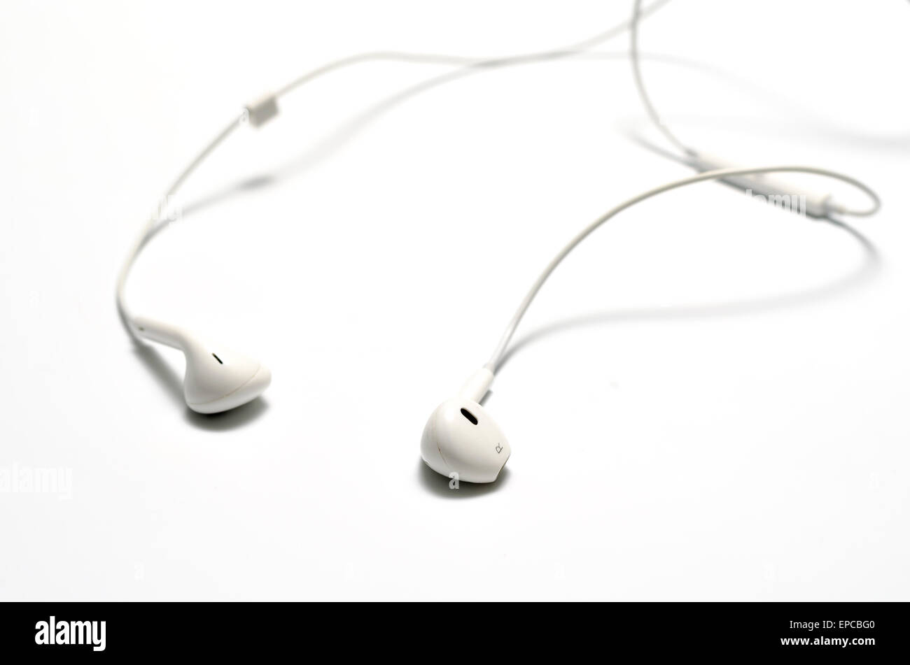 white earphones on a white background Stock Photo - Alamy