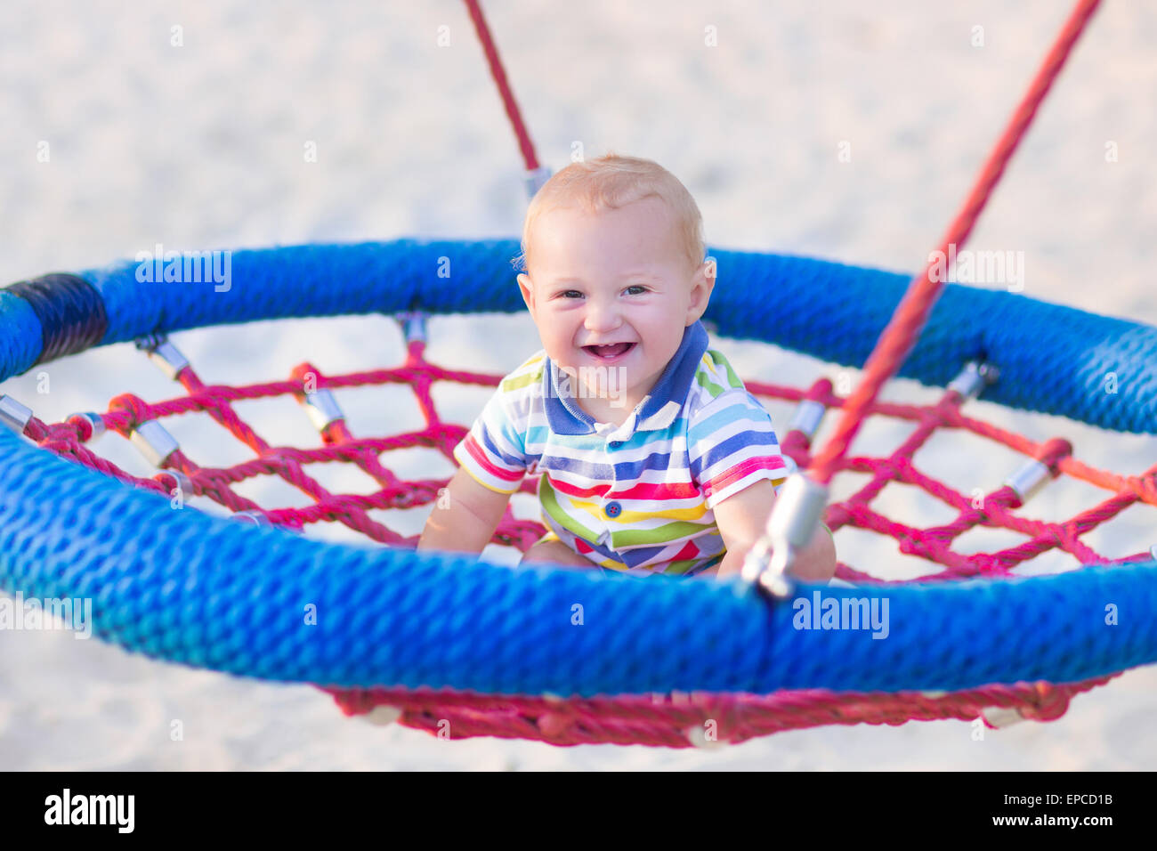 Happy laughing baby, adorable little boy enjoying a swing ride having ...