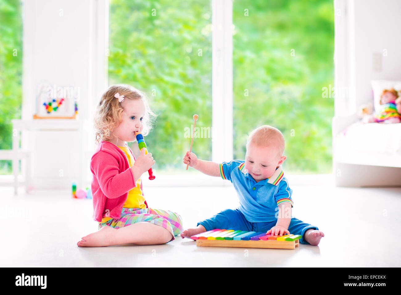 Two little children - cute curly toddler girl and a funny baby boy ...