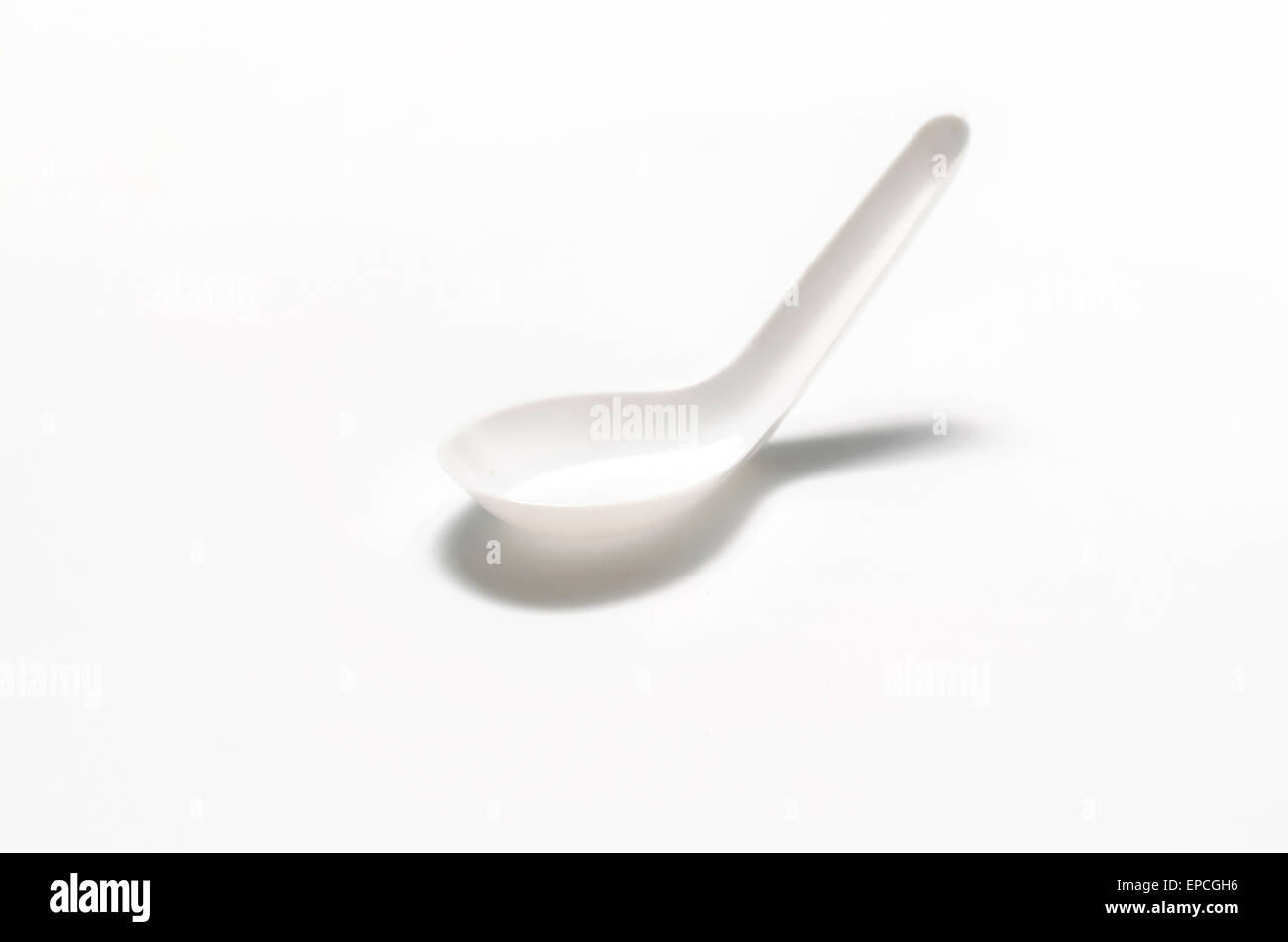 white plastic spoon on a white background Stock Photo - Alamy