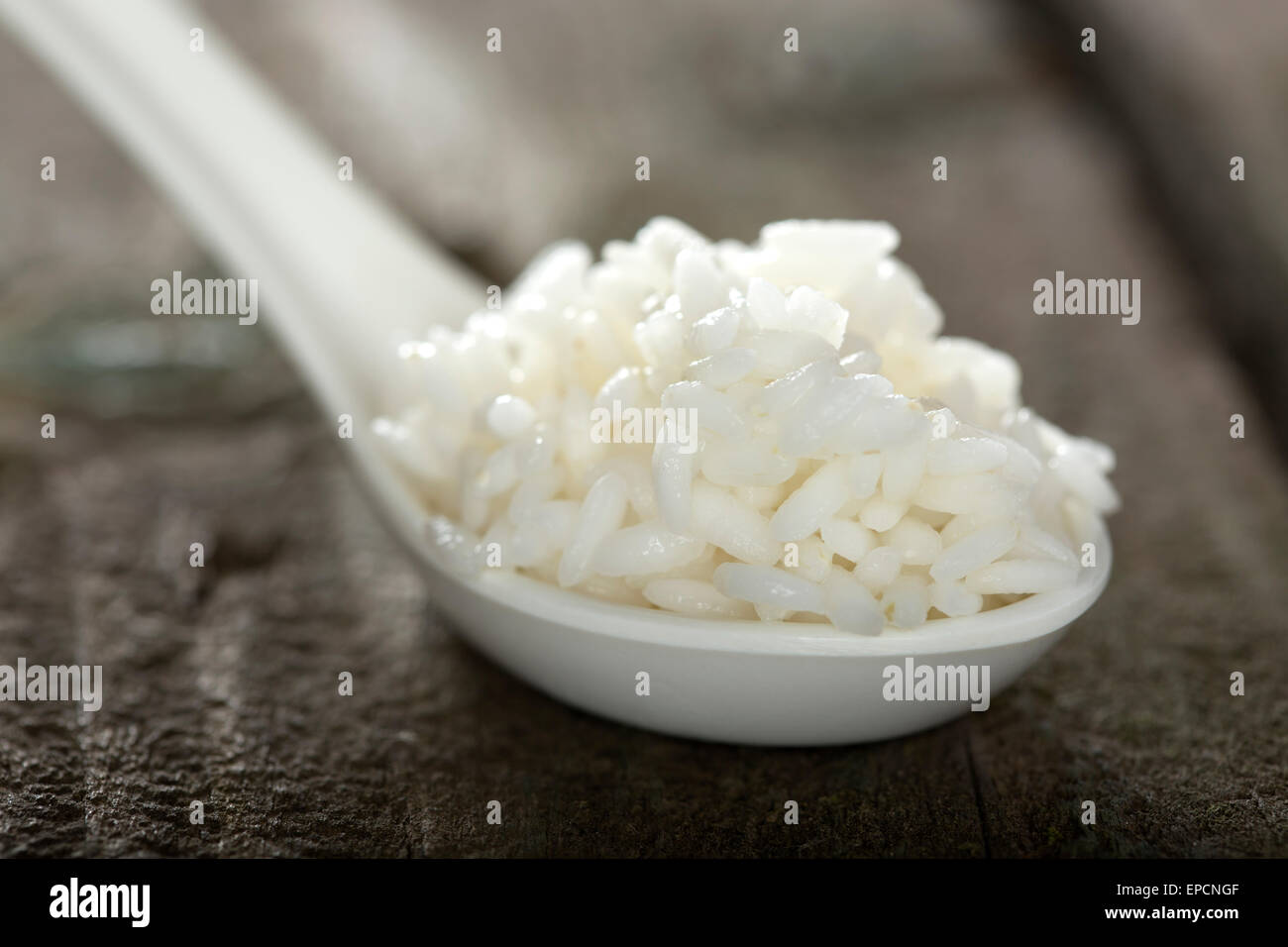 Spoon full of rice over wooden background Stock Photo - Alamy