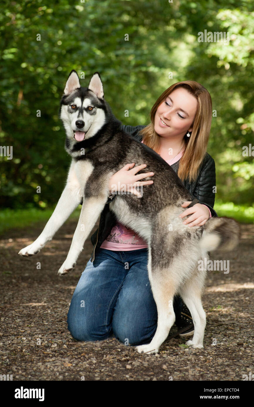 Young woman and her husky in the forest Stock Photo - Alamy