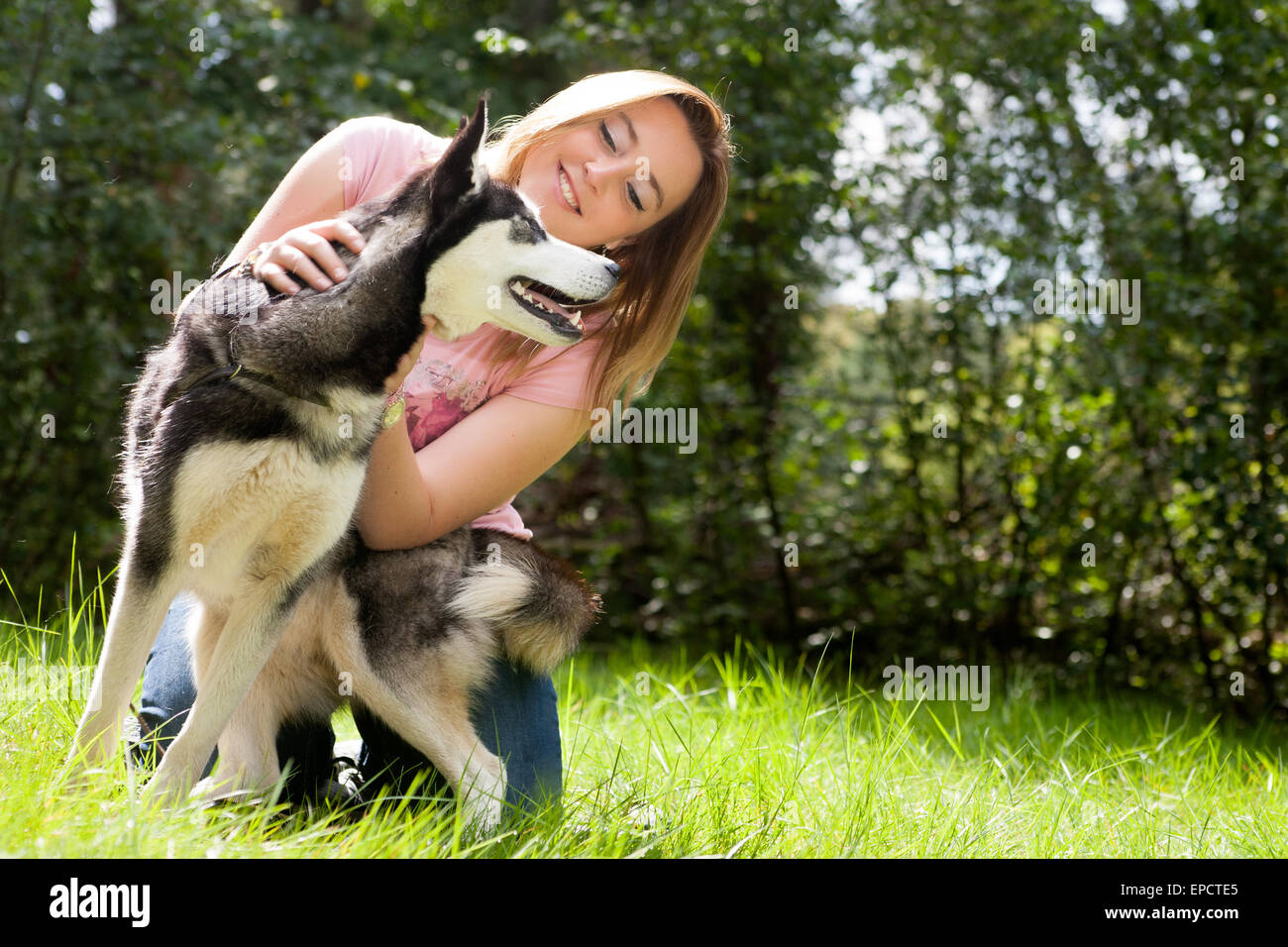 Young woman and her husky in the forest Stock Photo - Alamy