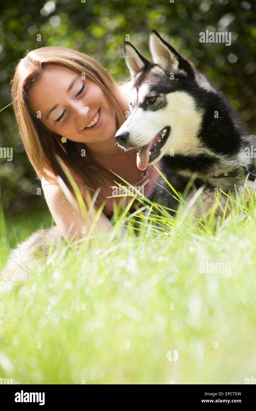 Young woman and her husky in the forest Stock Photo - Alamy