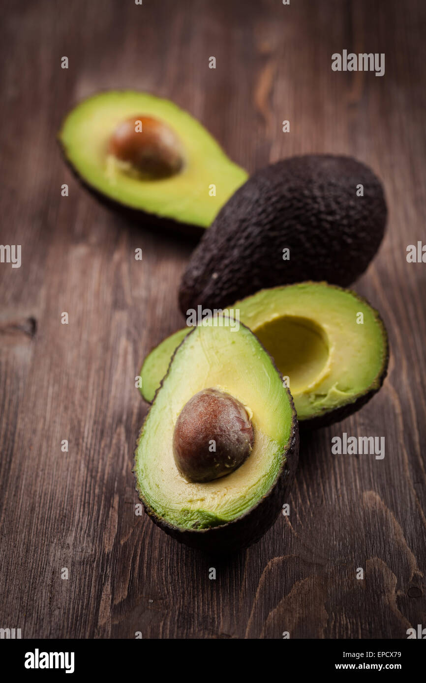 Avocado on wooden table Stock Photo - Alamy