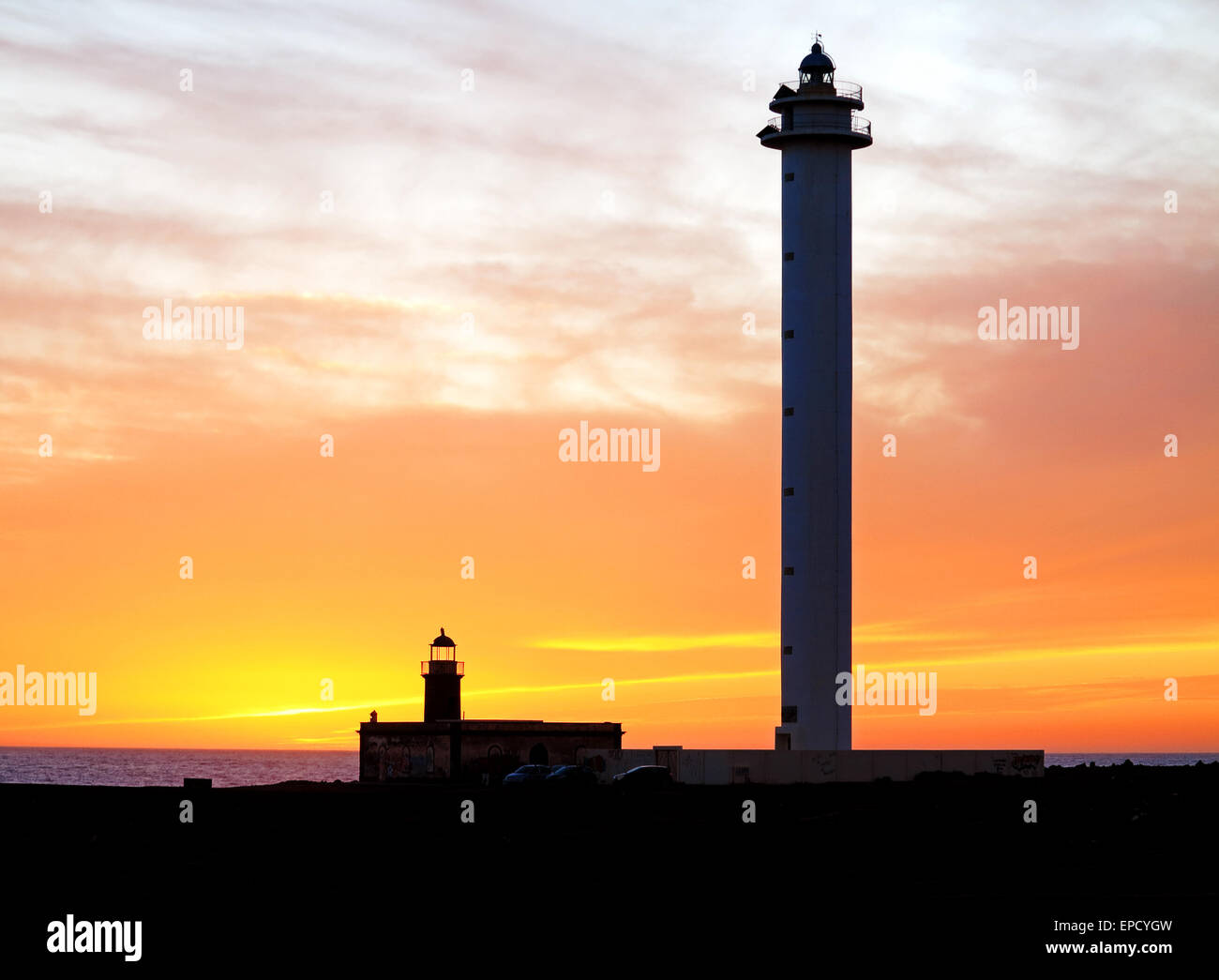 Lighthouse silhouetted against a glowing sunset at Faro Park Playa ...
