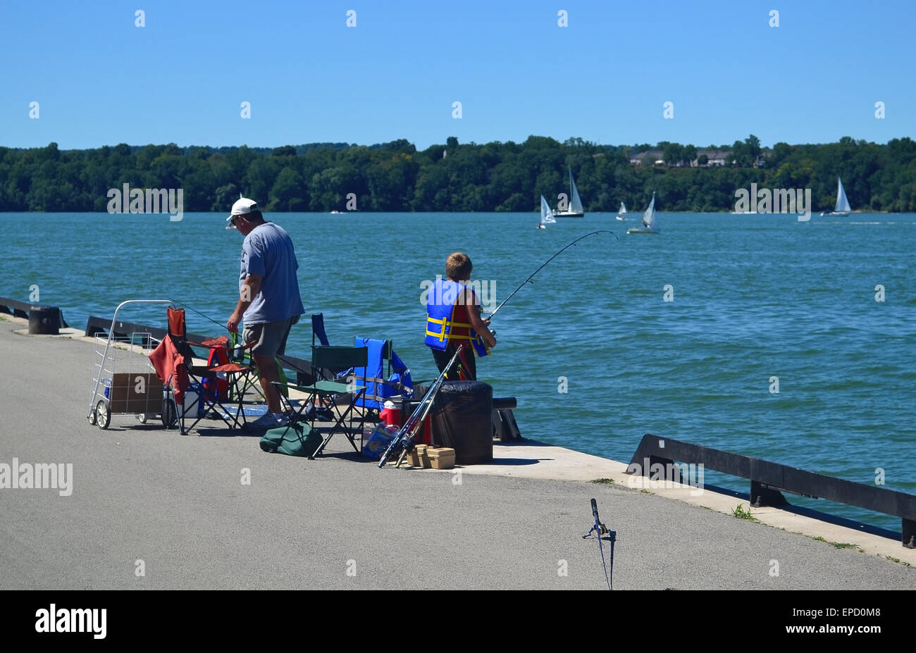 A grand father with his grand son are fishing on the harbour of ...