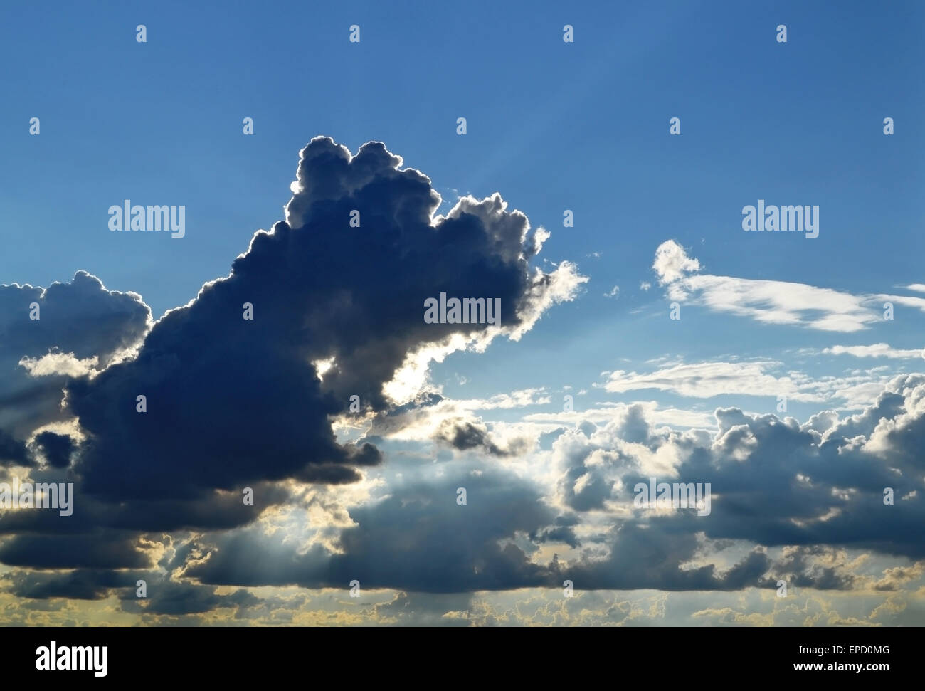 Under a bright blue sky are some dark clouds in front of the sun Stock ...